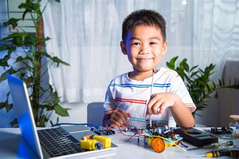 Arduino 로봇 자동차로 센서 칩에 에너지 및 신호 케이블을 연결하는 아시아 소년 프리미엄 사진
