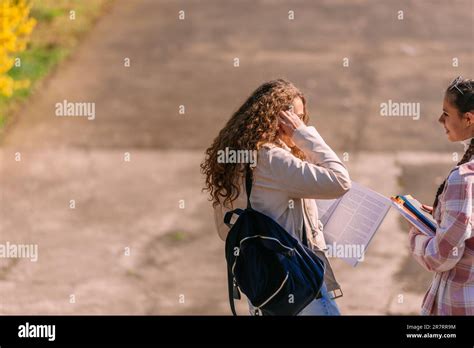Photo Of Two Young Girls Standing Next To Each Other And Having School