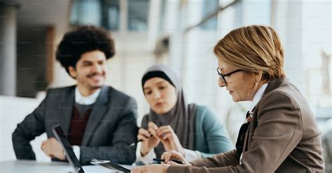 사무실에서 젊은 중동 부부와 회의를 하는 수석 부동산 중개인 사진 Unsplash의 실내 이미지