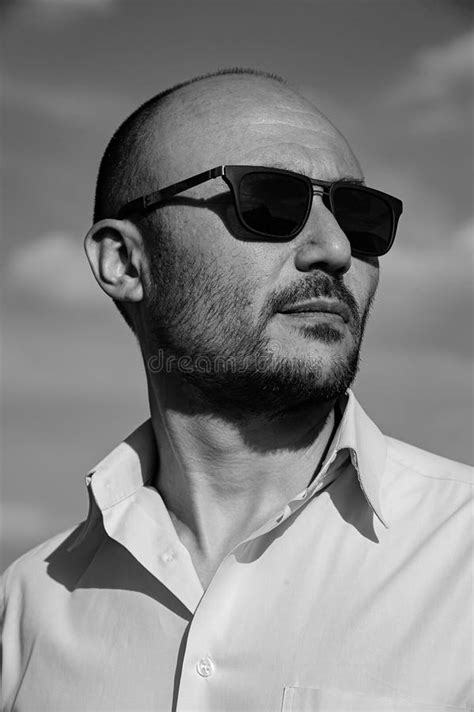 Portrait Of A Bearded Man Wearing Sunglasses Against The Sky Stock