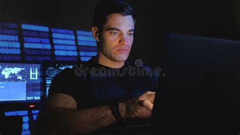 Handsome Male Hacker Programmer Works At A Computer At Night In A Data