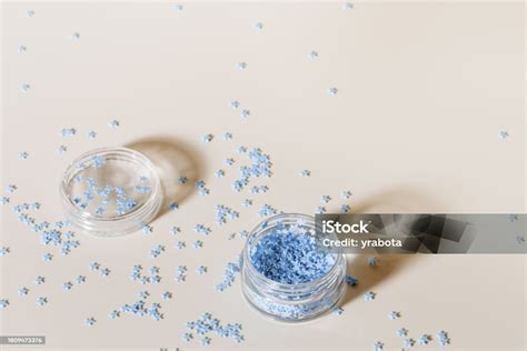손톱 장식을 위한 요소 네일 액세서리 상자의 파란색 별 베이지색 배경에 유리 항아리에 있는 네일 아트용 별 복사 공간 창조적 인 아름다움 개념 파스텔 색상 사진 시각적