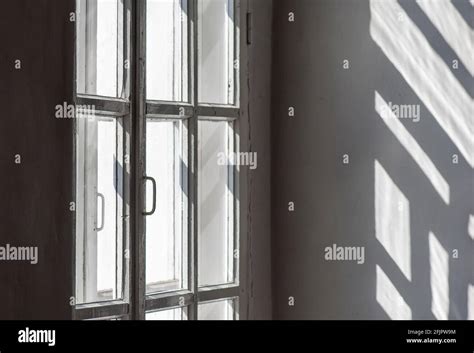 Interior Of Room With Window Frame Sunlight And Shadows On Wall Stock