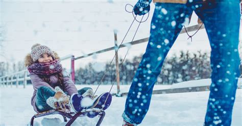 잘 생긴 젊은 아빠와 그의 귀여운 딸은 겨울에 야외에서 즐거운 시간을 보내고 있습니다 썰매를 타면서 함께 시간을 보내는 것을 즐깁니다 가족 개념입니다 사진