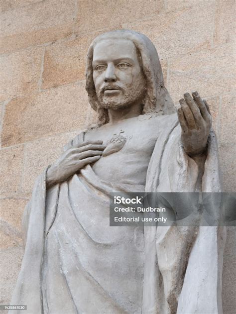 Statue Of Jesus Christ With Raised Hand Located On The Facade Of The