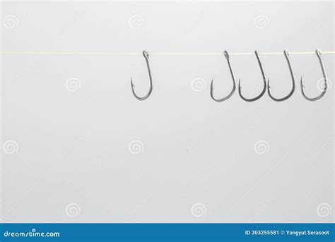 Hooked Hooks With Yellow Ropes Hang Many Together On A White Bac Stock