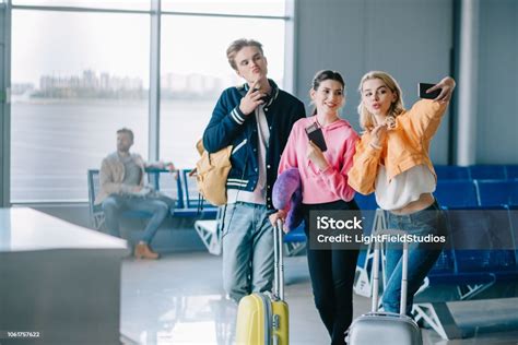 공항 터미널에서 스마트폰으로 Selfie를 복용 하는 젊은 친구 들을 웃 고 공항에 대한 스톡 사진 및 기타 이미지 공항