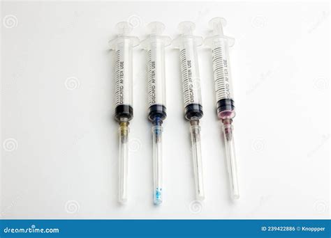 Used Syringes With A Protective Cap On The Needle With Colored