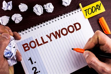 단어 쓰기 텍스트 볼리우드입니다 인도 영화 마커 오늘 종이 공을 들고 나무 배경에 메모장에 사람에 의해 작성 하는 엔터테인먼트의 소스에 대 한 비즈니스 개념 감독에 대한