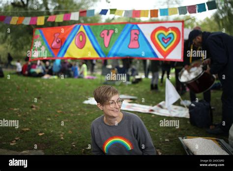 A Protester Sits Beneath A Love Banner During An Extinction Rebellion
