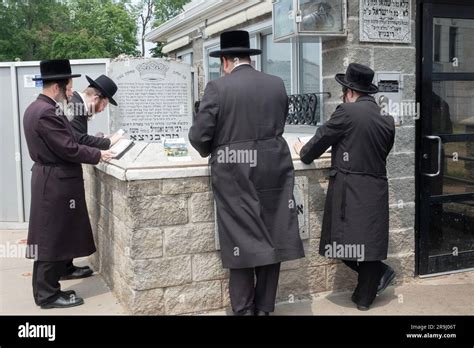 Four Jewish Men Pray At The Headstone Of The Ribnitz Rebbe As It Is