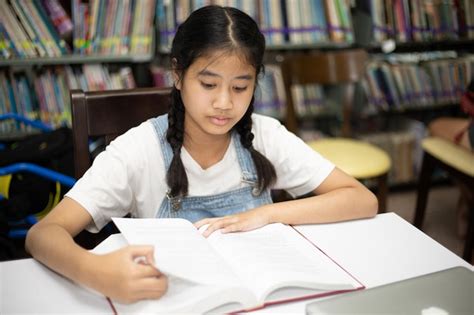 Premium Photo Girl Reading Book While Sitting In Library