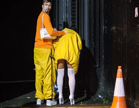 A Man Rubs A Womans Back As She Vomits In The Street After The Boxing