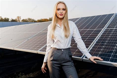 Blonde Model Smiles In Solar Panel Row On Power Plant Photo Background And Picture For Free