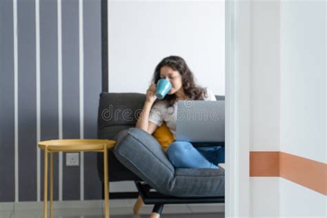 Beautiful Girl Sitting With A Laptop On A Sofa In A Stylish Room Work