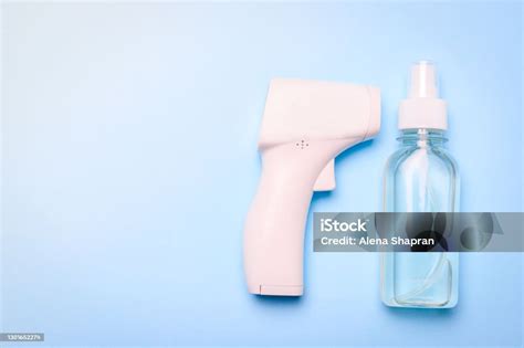 적외선 온도계 및 파란색 배경에 방부제 살 균 손의 치료 예방 비접촉 온도 측정 건강 코로나 바이러스 팬데믹 인간의 건강 온도를