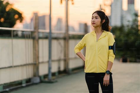 아름 다운 젊은 아시아 운동 선수 아가씨는 도시 환경에서 스트레칭 운동을합니다 이른 아침에 보도 다리에서 운동복을 입은 일본