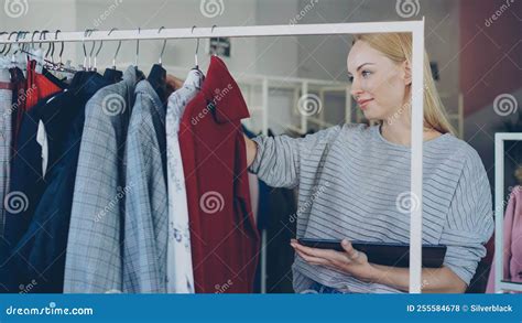 Young Businesswoman Is Checking Garments On Rails And Working With