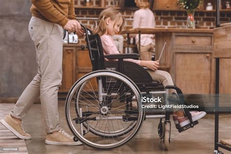 귀여운 작은 딸 집에서 노트북을 사용 하 여 휠체어를 들고 아버지의 총을 자른 휠체어에 대한 스톡 사진 및 기타 이미지 휠체어 아이 한 명의 자녀를 둔 가족 Istock