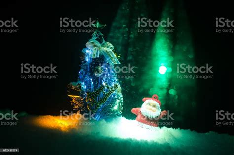나무와 눈 크리스마스 시간에 행복 한 산타 클로스 인형 다채로운 Bokeh 배경입니다 어두운 톤에 산타 조항 및 메리 크리스마스