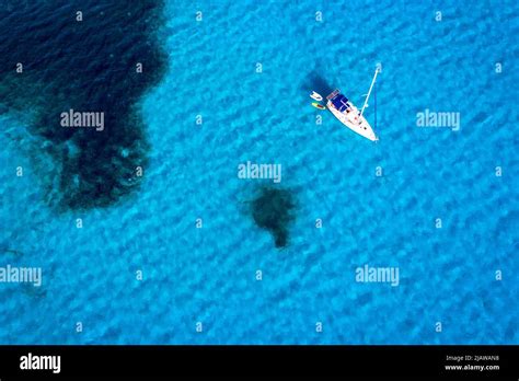 Yacht Anchoring In Crystal Clear Turquoise Water In Front Of The