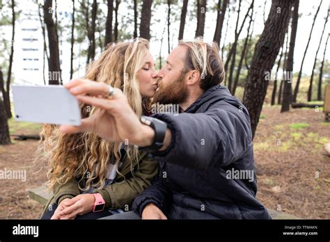 Romantic Couple Kissing While Taking Selfie Through Smart Phone In