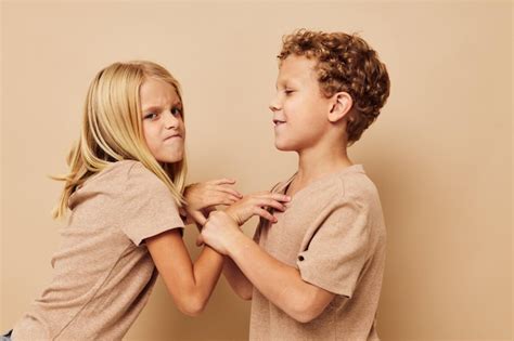 Premium Photo Side View Of Sibling Fighting Against Beige Background