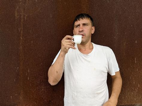 Premium Photo Portrait Of Young Man Drinking Glass Against Wall