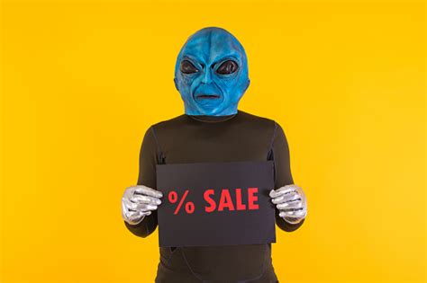Foto De Homem Com Uma Máscara Alienígena Com Uma Cabeça Azul Segurando Uma Placa Preta Com