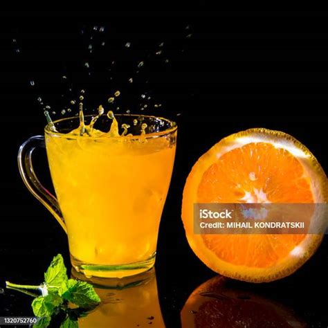 오렌지 주스와 민트 반 오렌지와 함께 유리에 튀기고 검은 색 배경에 건강한 라이프 스타일 개념 복사 공간 부양 0명에 대한 스톡
