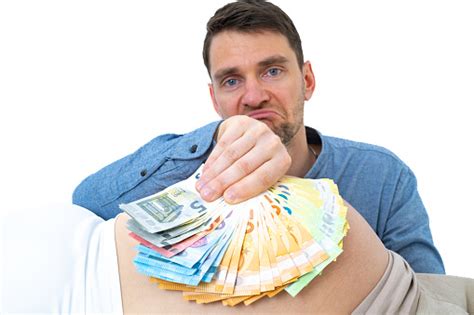 임산부는 아내의 임신한 아기 범프 위에 큰 지폐 더미를 들고 감명을 받지 않은 것처럼 보입니다 임신 마지막 달 39 주 흰색 배경입니다 밝은 샷 가족에 대한 스톡 사진 및