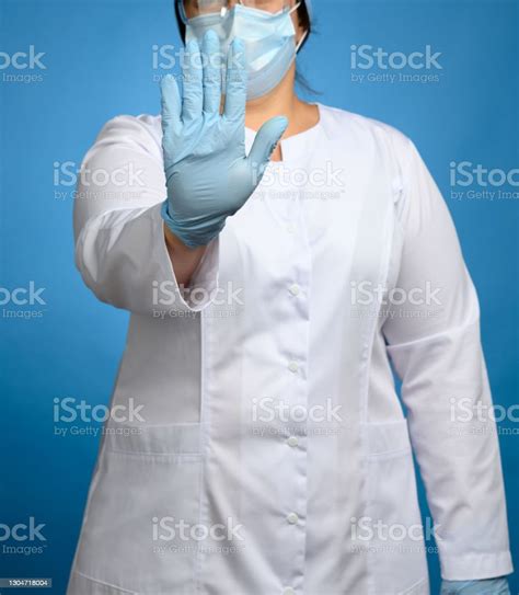 흰색 의료 코트와 파란색 라텍스 장갑의 의사가 안전한 거리를 유지하는 제스처 개념을 보여줍니다 40 49세에 대한 스톡 사진 및