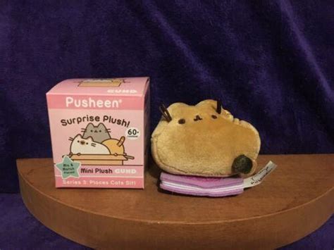 Gund Pusheen Blind Box Series 3 Plush Keychains Sitting On Book