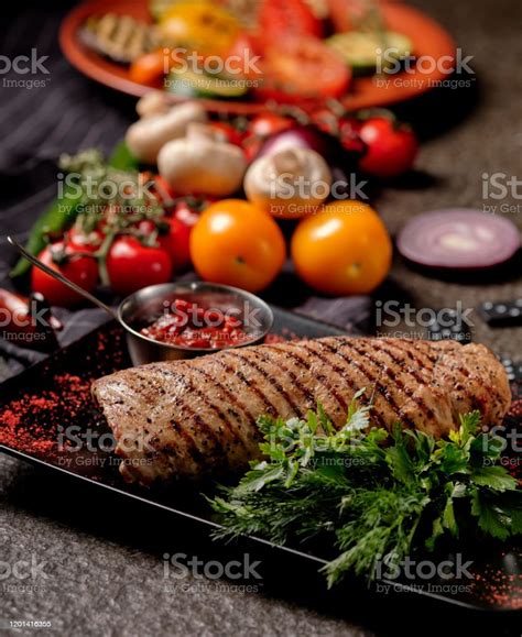 최고의 전망 맛있는 스테이크 돼지 허리 로스트 레드 바베큐 소스 검은 돌 배경에 야채와 향신료와 채소를 요리 구운 고기 맛있는