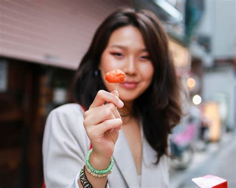 Premium Photo Portrait Of Young Woman Holding Candy