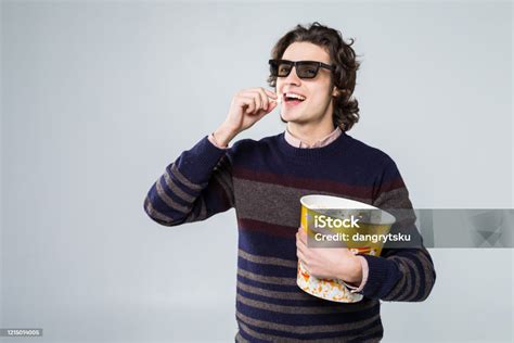 젊은 잘 생긴 남자 와 3d 안경 과 들고 큰 양동이 의 팝콘 위에 고립 된 흰색 배경 가리키기에 대한 스톡 사진 및 기타