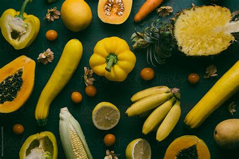 Assorted Yellow Fruits And Vegetables On Dark Background By Stocksy