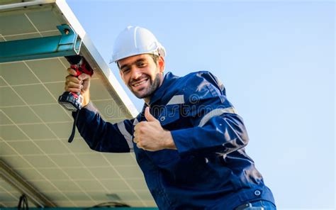 Male Technician Worker Installing Solar Panels At Solar Cell Farm Stock