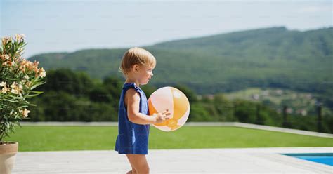 뒤뜰 정원에서 야외를 산책하는 공을 가진 작은 유아 소녀의 측면 보기 초상화 사진 Unsplash의 슬로바키아 이미지