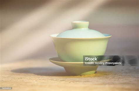 대리석 바닥의 Gaiwan은 태양 광선의 선택적 초점입니다 공푸차 다도 주 야오의 중국 도자기 중국 도자기 가이완 찻잔과 뚜껑 뚜껑이 달린 찻그릇 푸어 일본식 찻잔에 대한