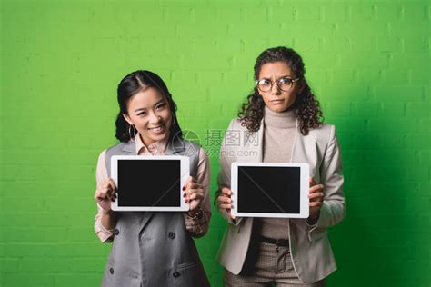 非洲裔美籍和亚裔女企业家在绿色墙前展示数高清图片下载 正版图片503360080 摄图网