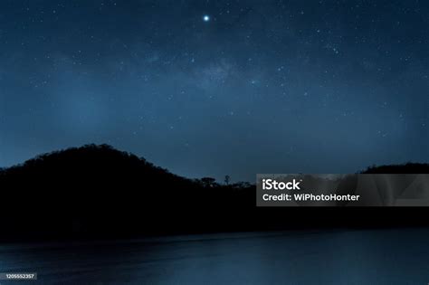 宇宙空間拍攝的星雲和銀河的全景圖在藍天上有星星在令人驚歎的星空下山上的孤獨高老松樹的剪影的美麗場景 照片檔及更多 側影 照片 Istock