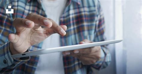 빨간색과 파란색 격자 무늬 버튼 업 셔츠를 입은 남자가 흰색 태블릿 컴퓨터를 들고 사진 Unsplash의 무료 남자 이미지