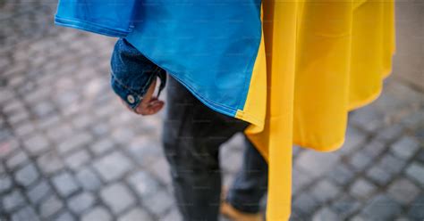 거리에서 우크라이나의 전쟁에 항의하는 파란색과 노란색 우크라이나 국기로 덮인 시위대의 낮은 부분 사진 Unsplash의 시티 스트리트 이미지