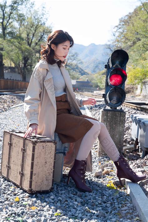 青年女人坐在铁轨旁边 包图企业站