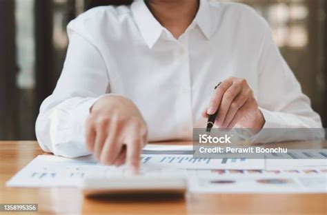 사무실 비즈니스 개념에서 비즈니스 데이터 회계 문서 및 랩톱 컴퓨터를 계산하기 위해 계산기에서 일하는 사업가 또는 회계사