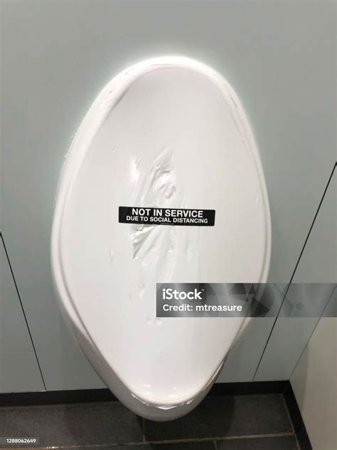 남자를 위한 공항 터미널 공중 화장실에 밀봉된 벽 장착 소변기의 이미지 코로나바이러스 사회 분리 규정을 시행하는 스티커