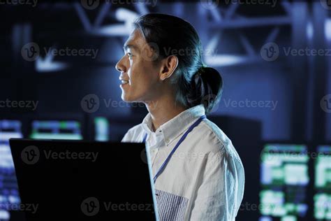 Cheerful Bipoc Man Between Server Hub Rows Providing Processing Resources For Businesses