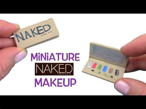 Two Hands Are Holding Small Miniature Fake Makeup Items In Front Of The Camera And One Hand Is