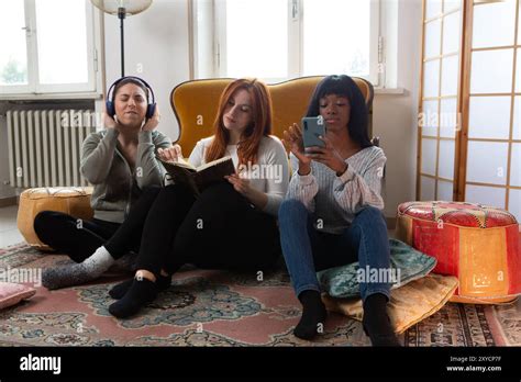 Three Female Roommates Are Relaxing At Home Listening To Music
